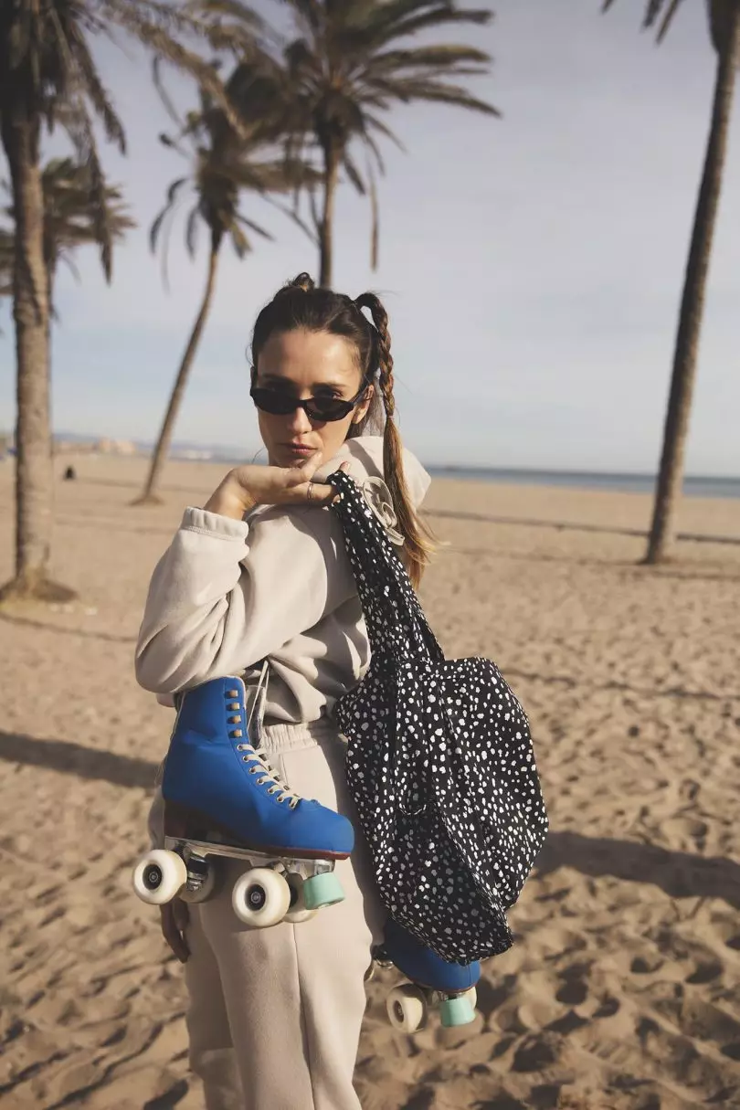 ragazza in spiaggia che porta una borsa